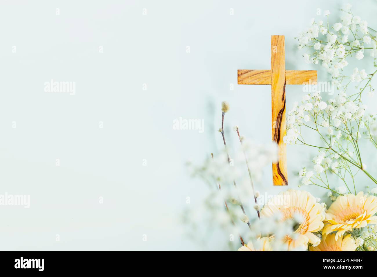 Wooden cross with spring flowers on blue background with copy space ...