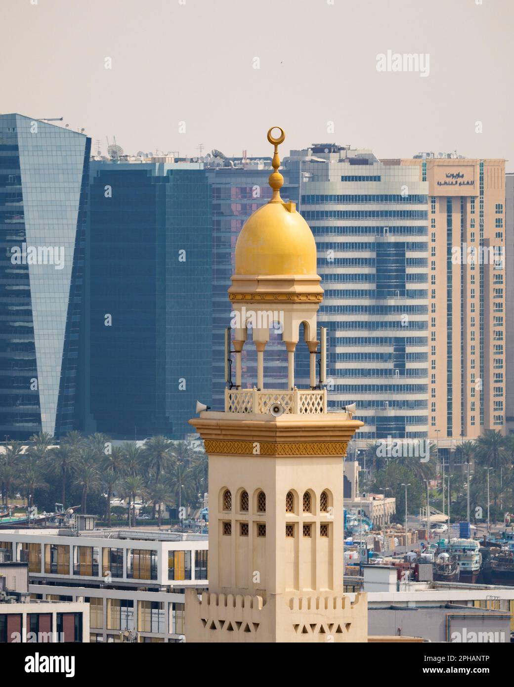 A majestic yellow clock tower illuminated by the evening sun, towering ...