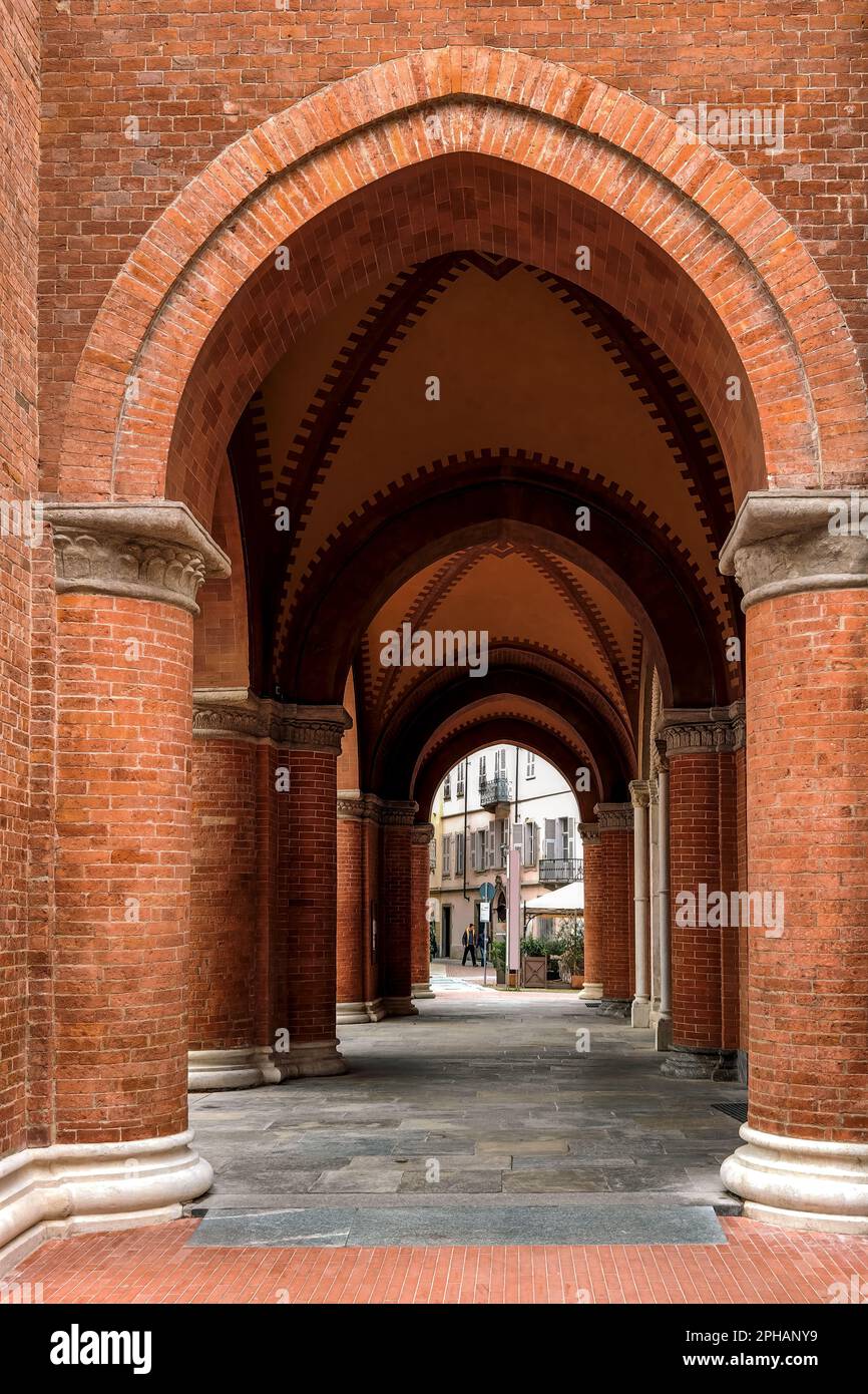 Passage through red brick walls and columns under vaulted ceiling in ...