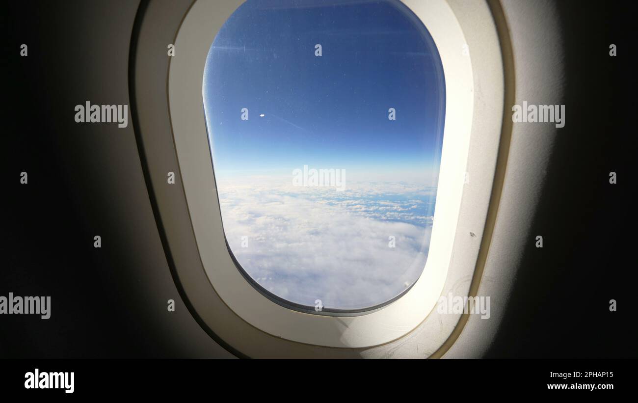 Airplane window in the air high above. Passenger plane POV looking out ...