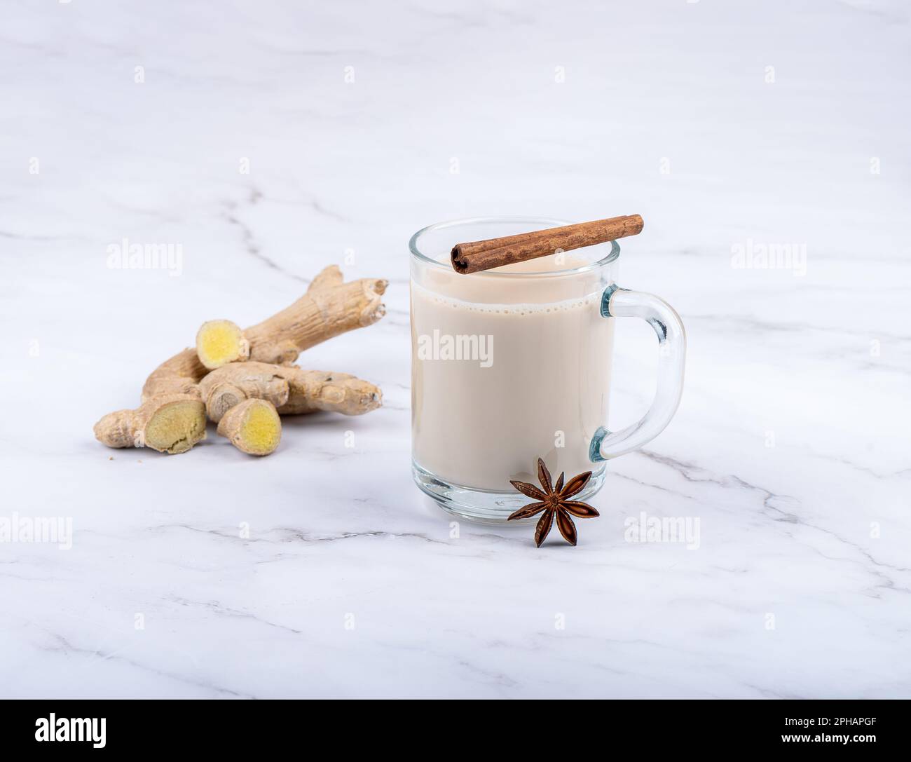 Glass mug with masala chai, ginger root, cinnamon and anise. Copy space ...