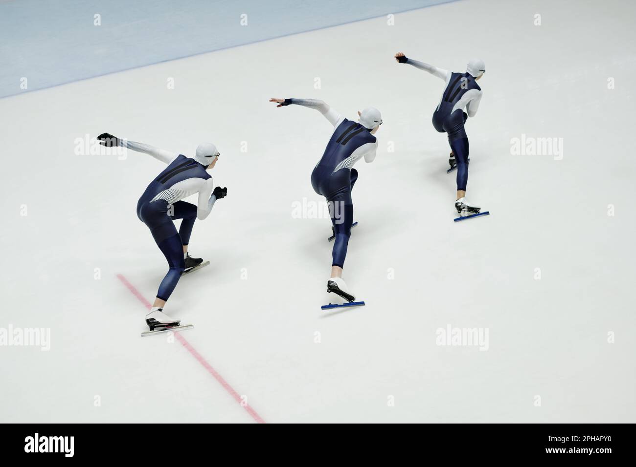 High angle of three young men in sports uniform and skates moving ...