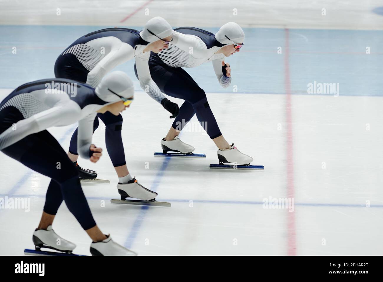 Side view of three professional short track speed skaters in sports ...