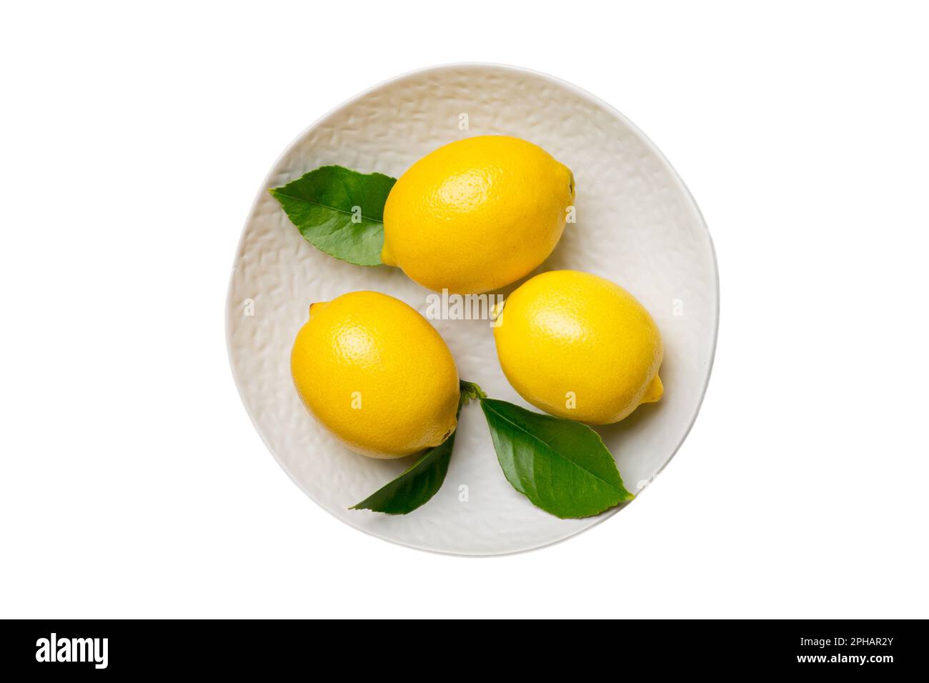 Fresh cutted lemon and whole lemons over round plate isolated on white ...