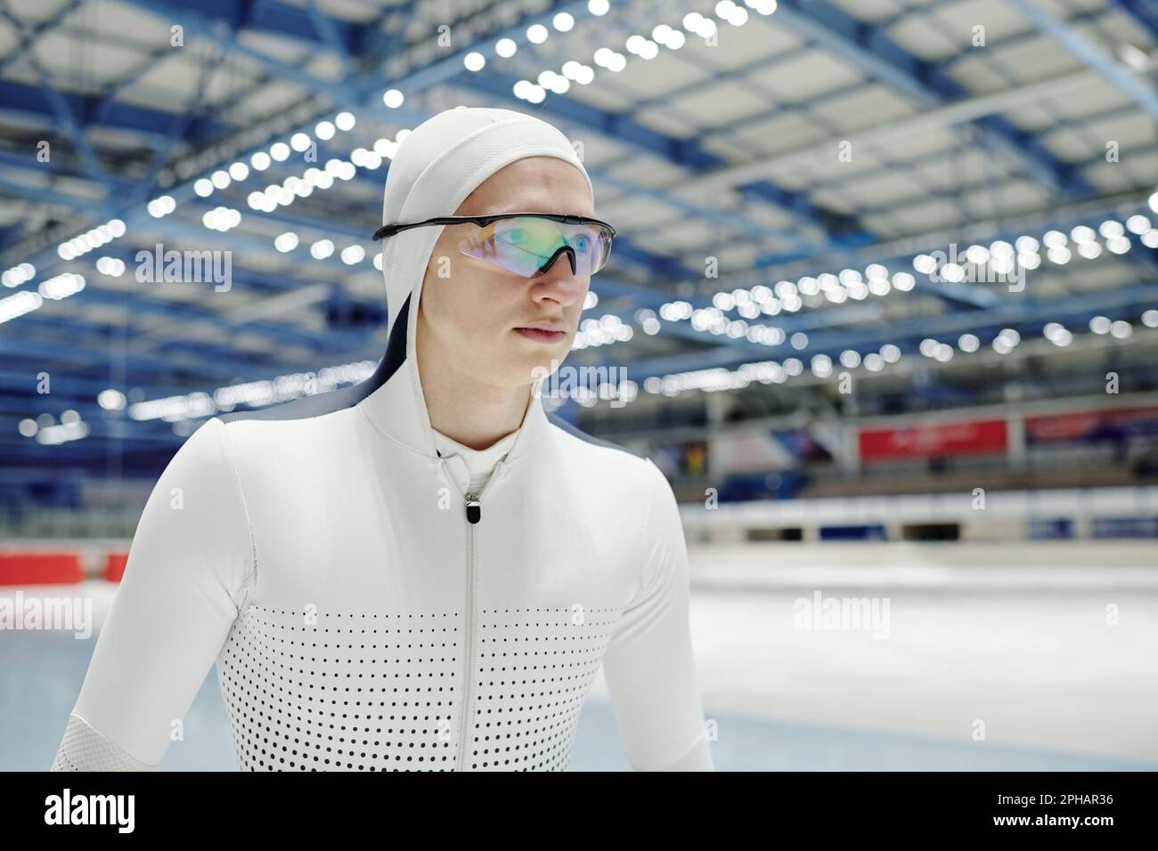 Young male short track speed skater in sports uniform and protective ...
