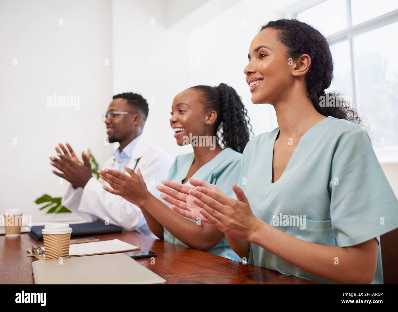 Three doctors in a row, clapping at medical presentation in hospital ...