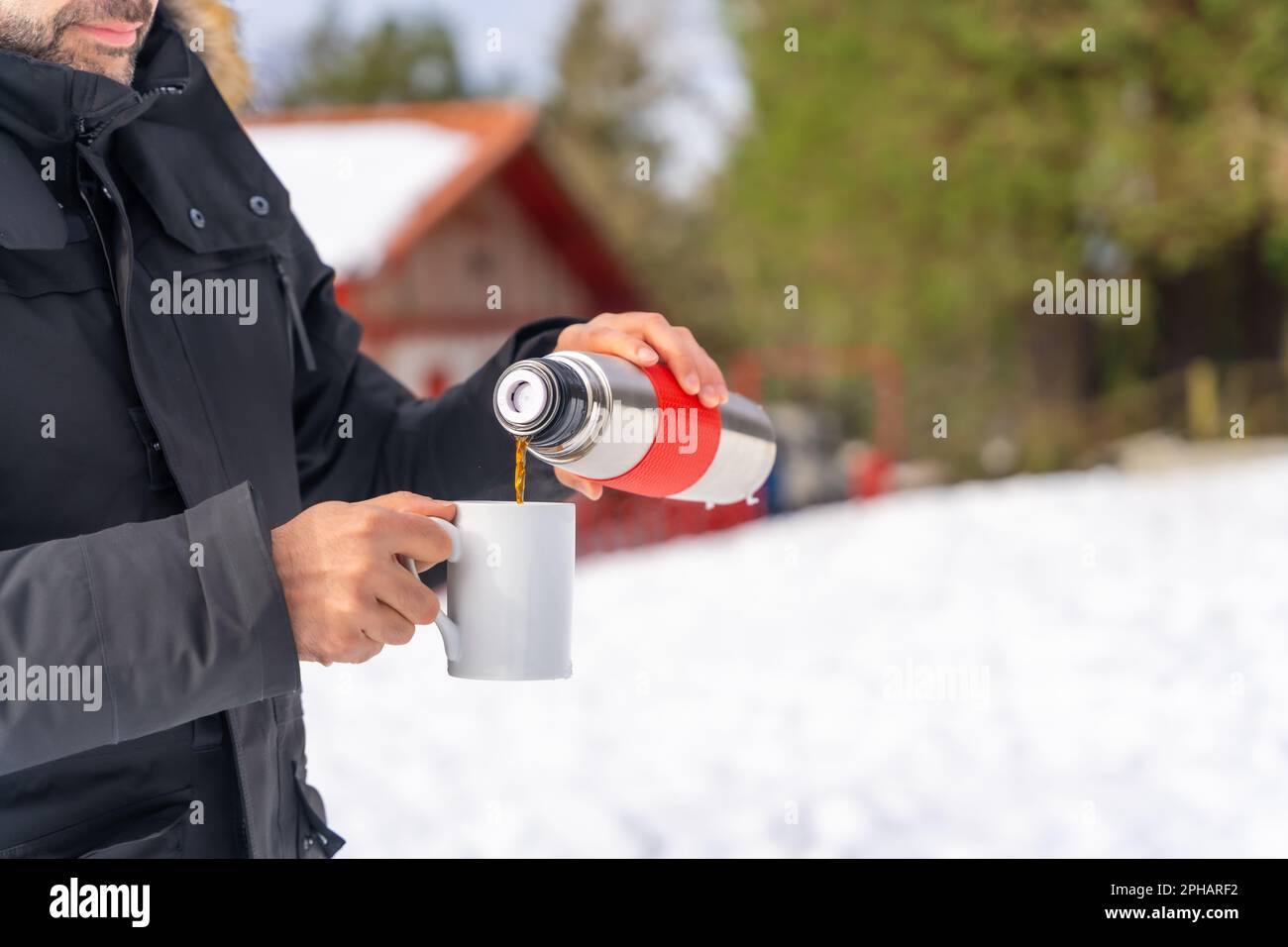 A man drinking hot coffee from a thermos in winter in the snow Stock ...