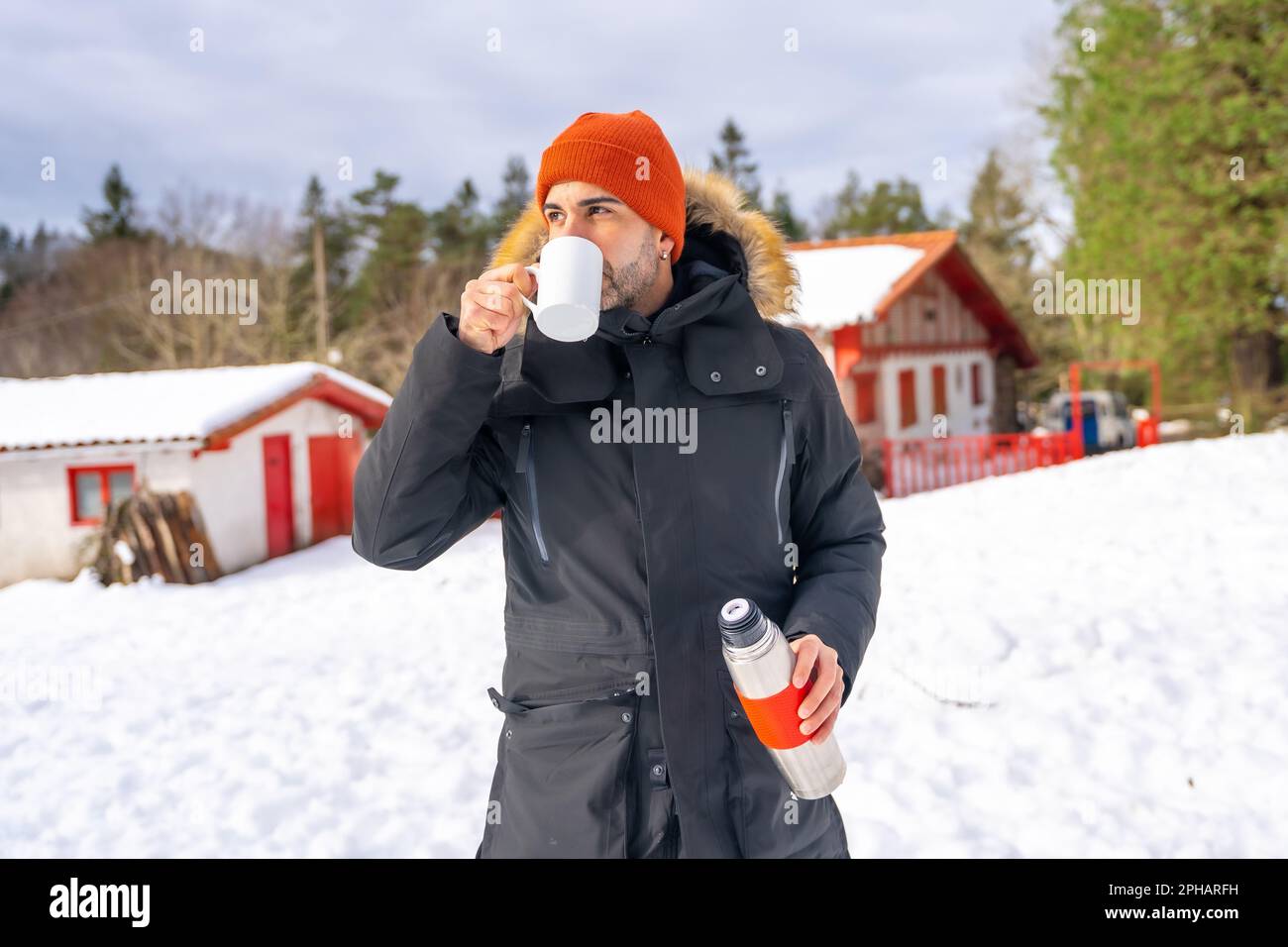 A man drinking hot coffee from a thermos in winter in the snow Stock ...