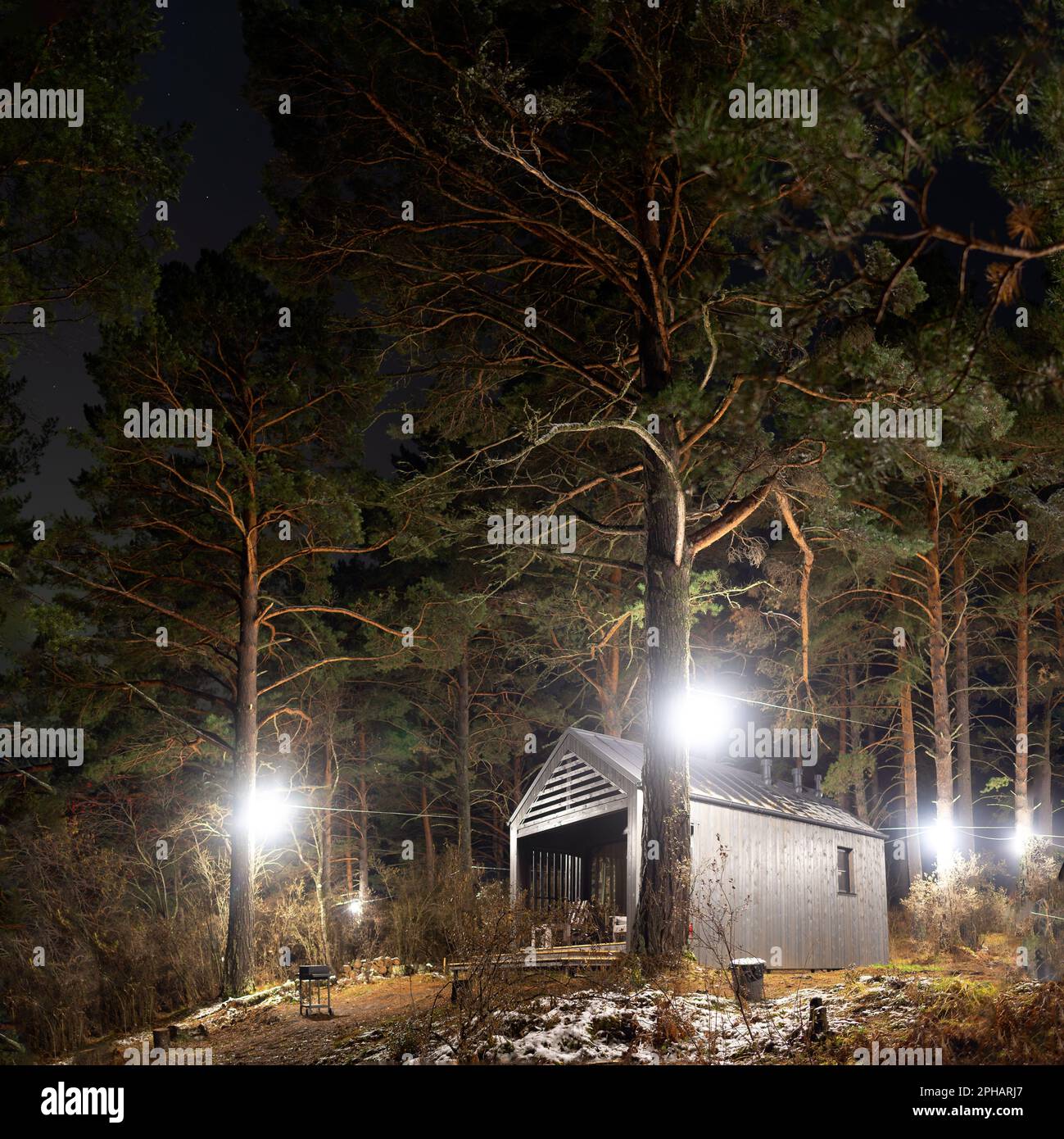 Cottage barnhouse for rest made of dark wood stands at night in the ...