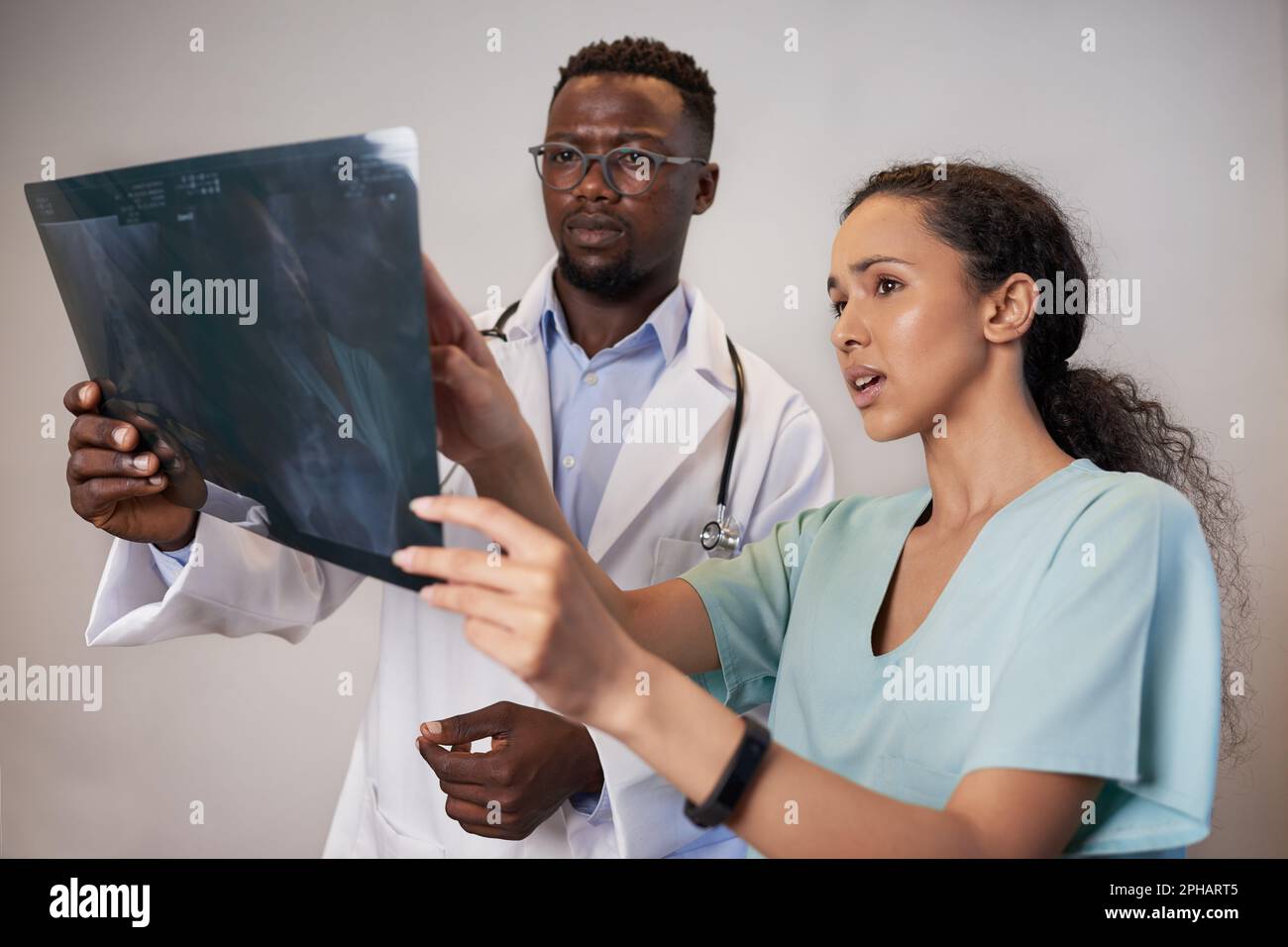 Two doctors review patient x-ray and discuss medical surgery treatment ...