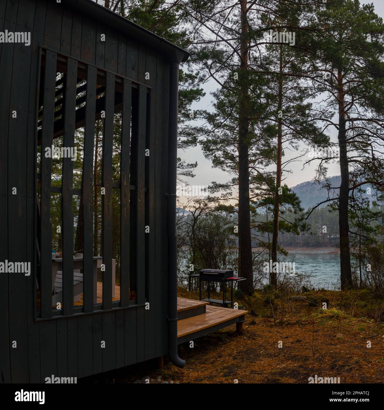 The slatted wall of a cottage barnhouse with a brazier on the shore in ...