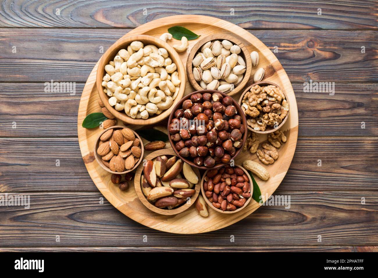 mixed nuts in wooden bowl. Mix of various nuts on colored background ...