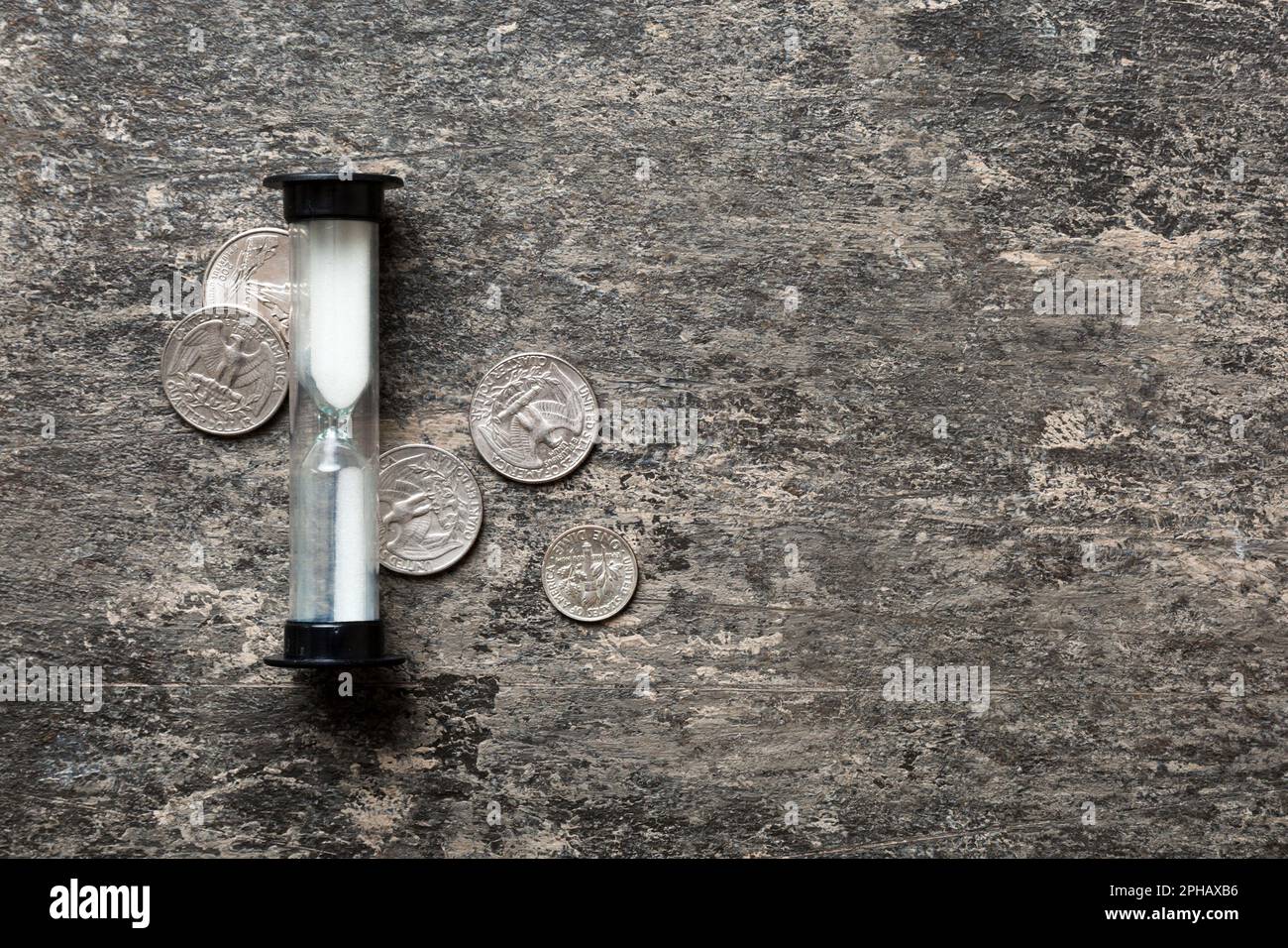 Deadline and time is money concept with hourglass and US coins currency ...