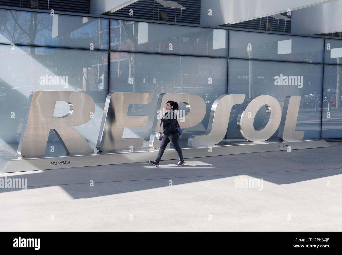 A woman walks in front of the letters Repsol at its headquarters on ...