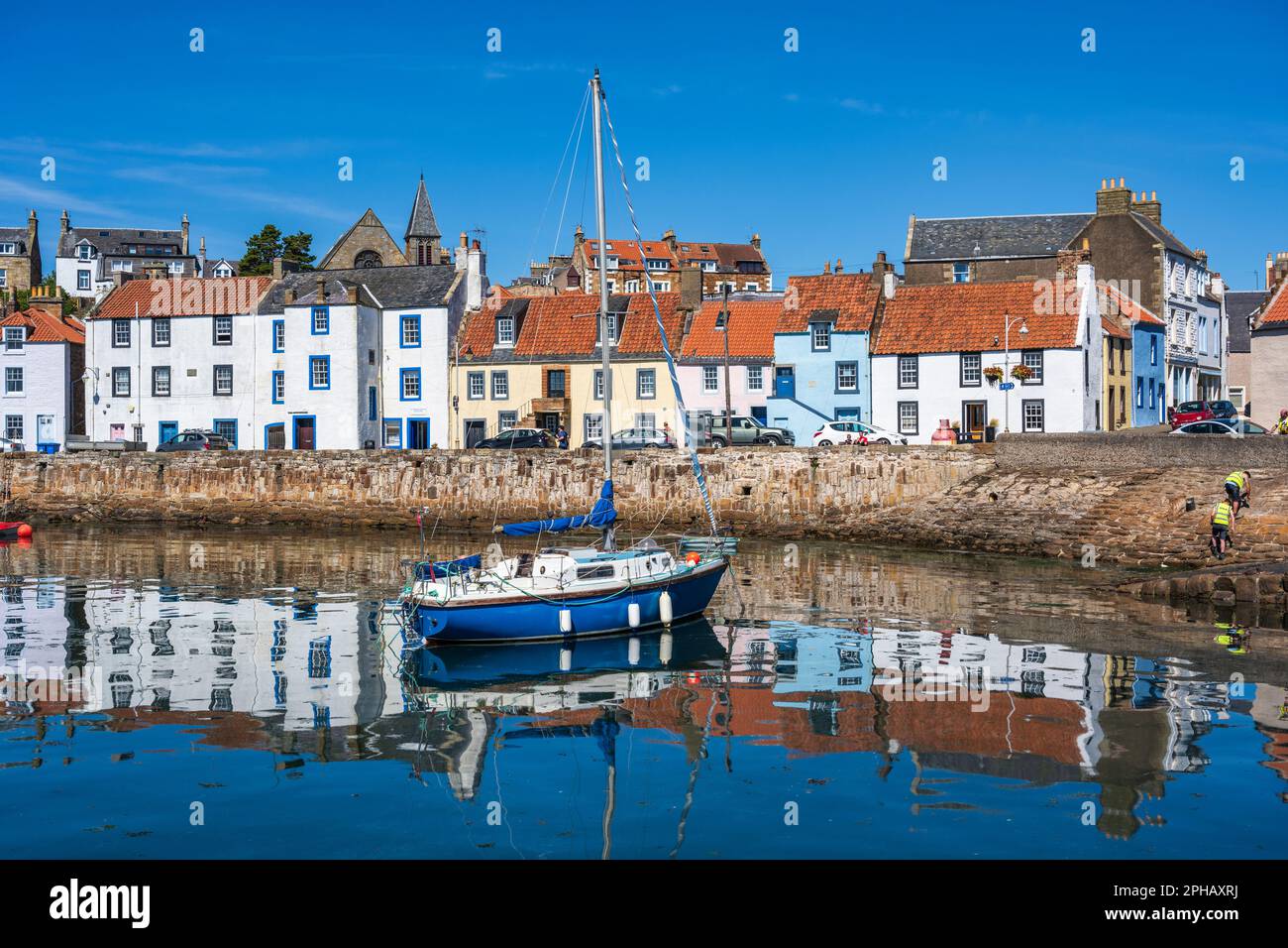 Yacht at anchor with colourful reflections of seafront houses at St ...