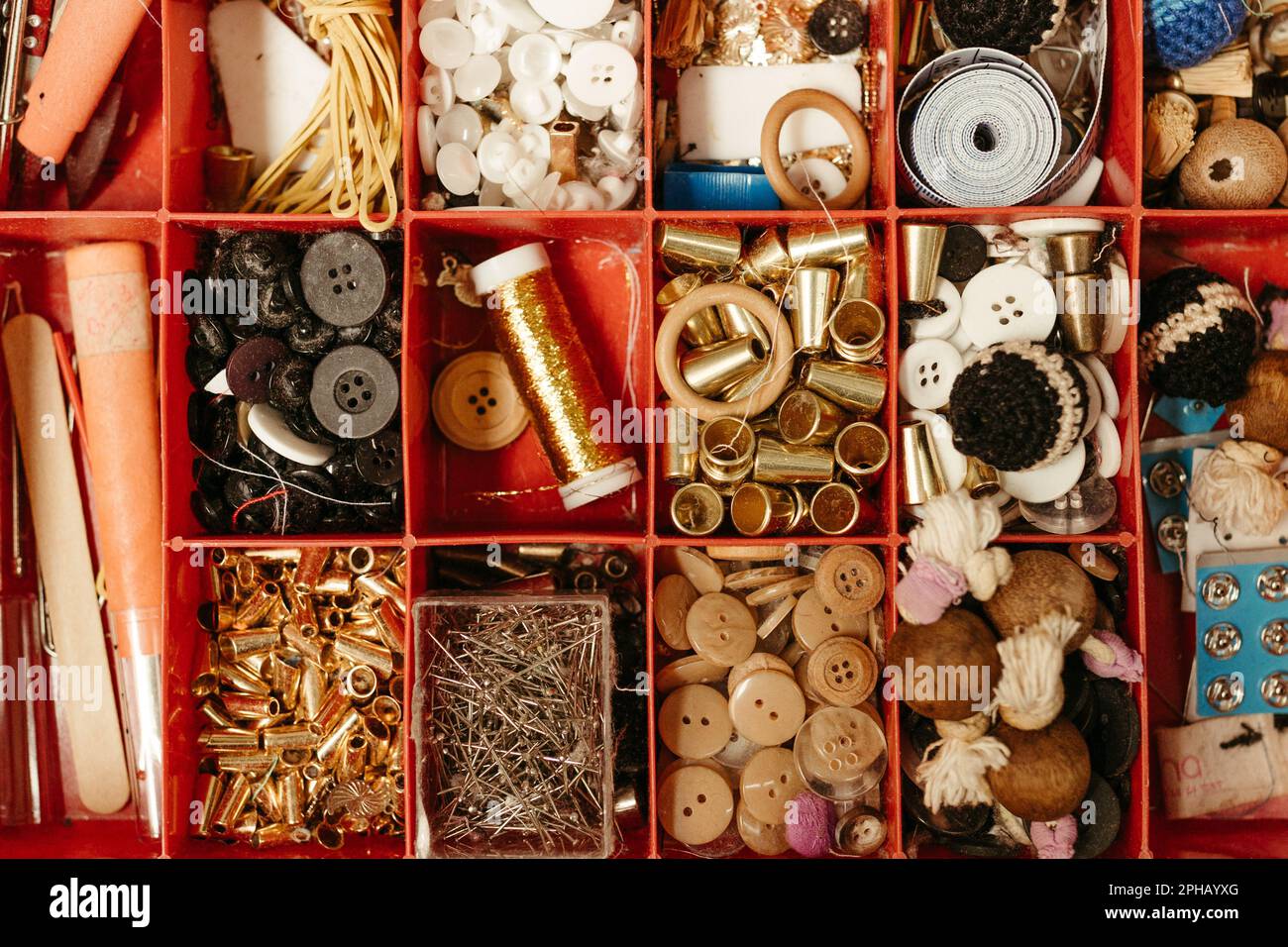 An open red box filled with sewing supplies, including scissors ...