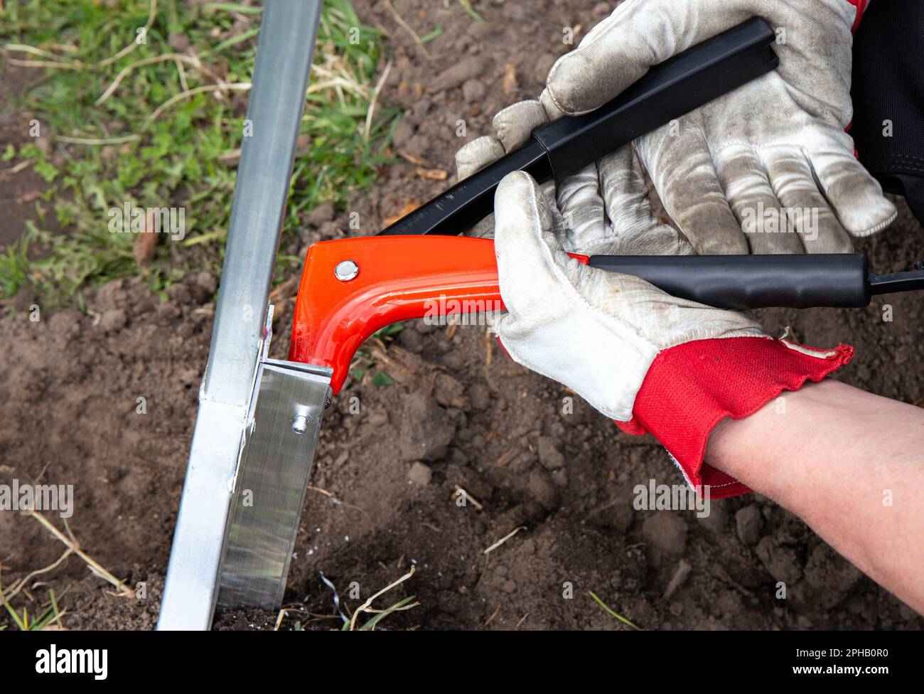 Close up view of man hand use rivet gun to install greenhouse metal ...