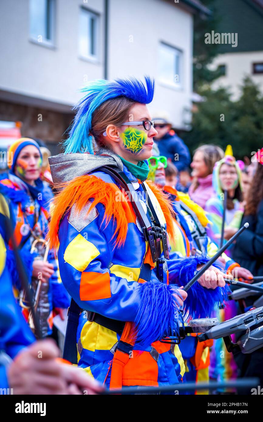 A cheerful group of people dressed in vibrant, colorful costumes ...