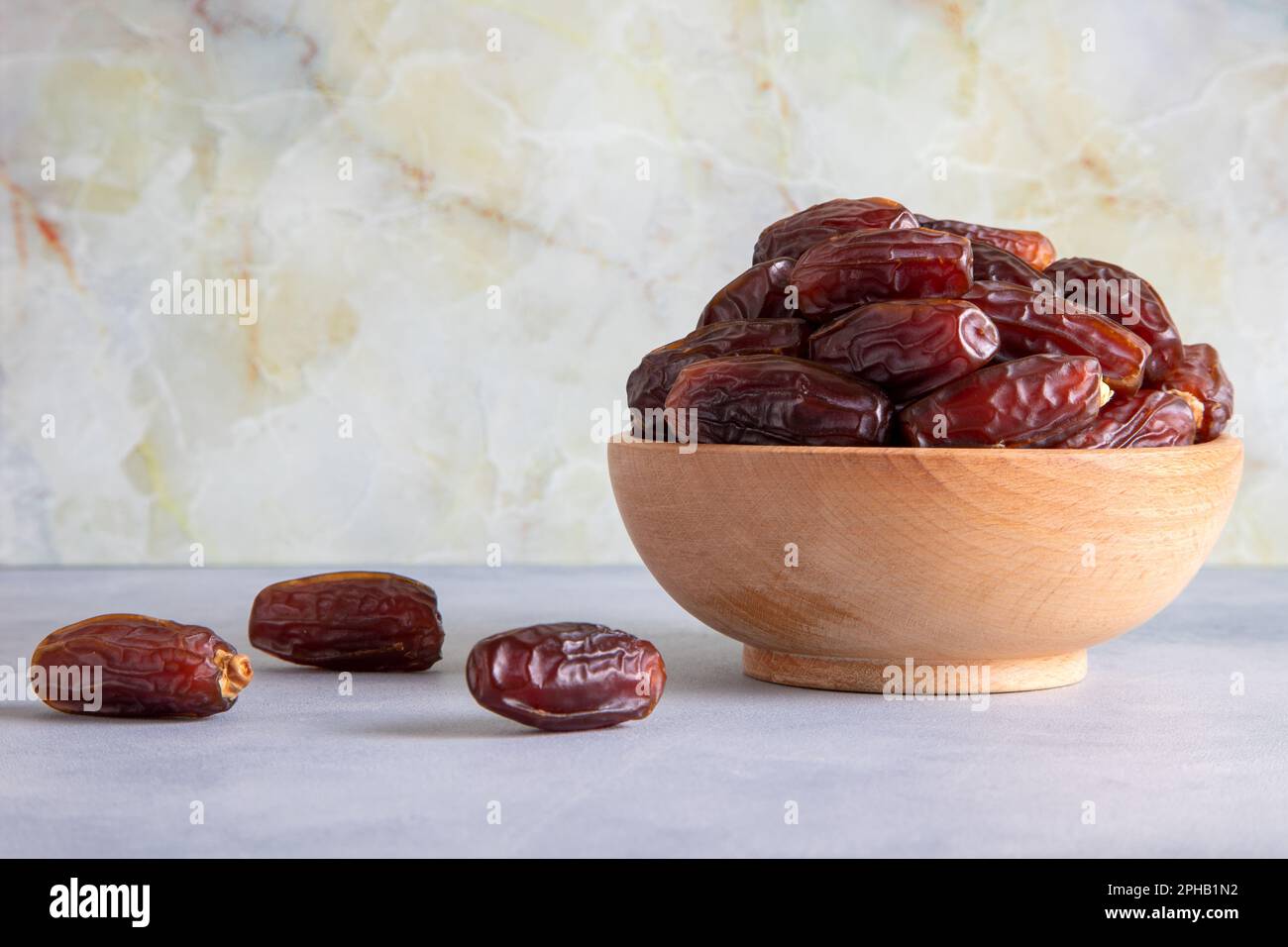 Date fruits in wooden bowl,on bright background Stock Photo - Alamy