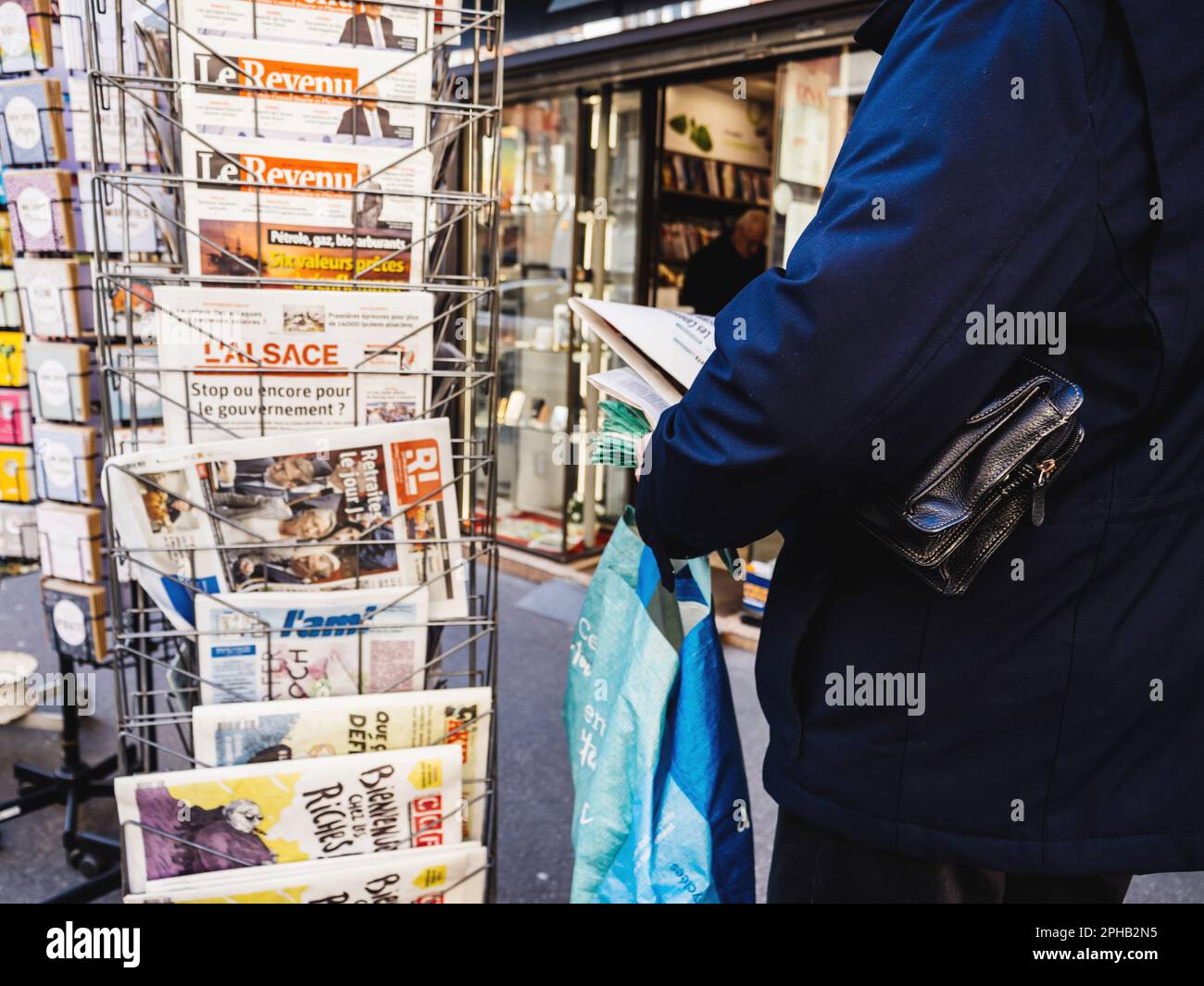 Paris, France - Mar 20, 2023: Senior buying press at kiosk with ...