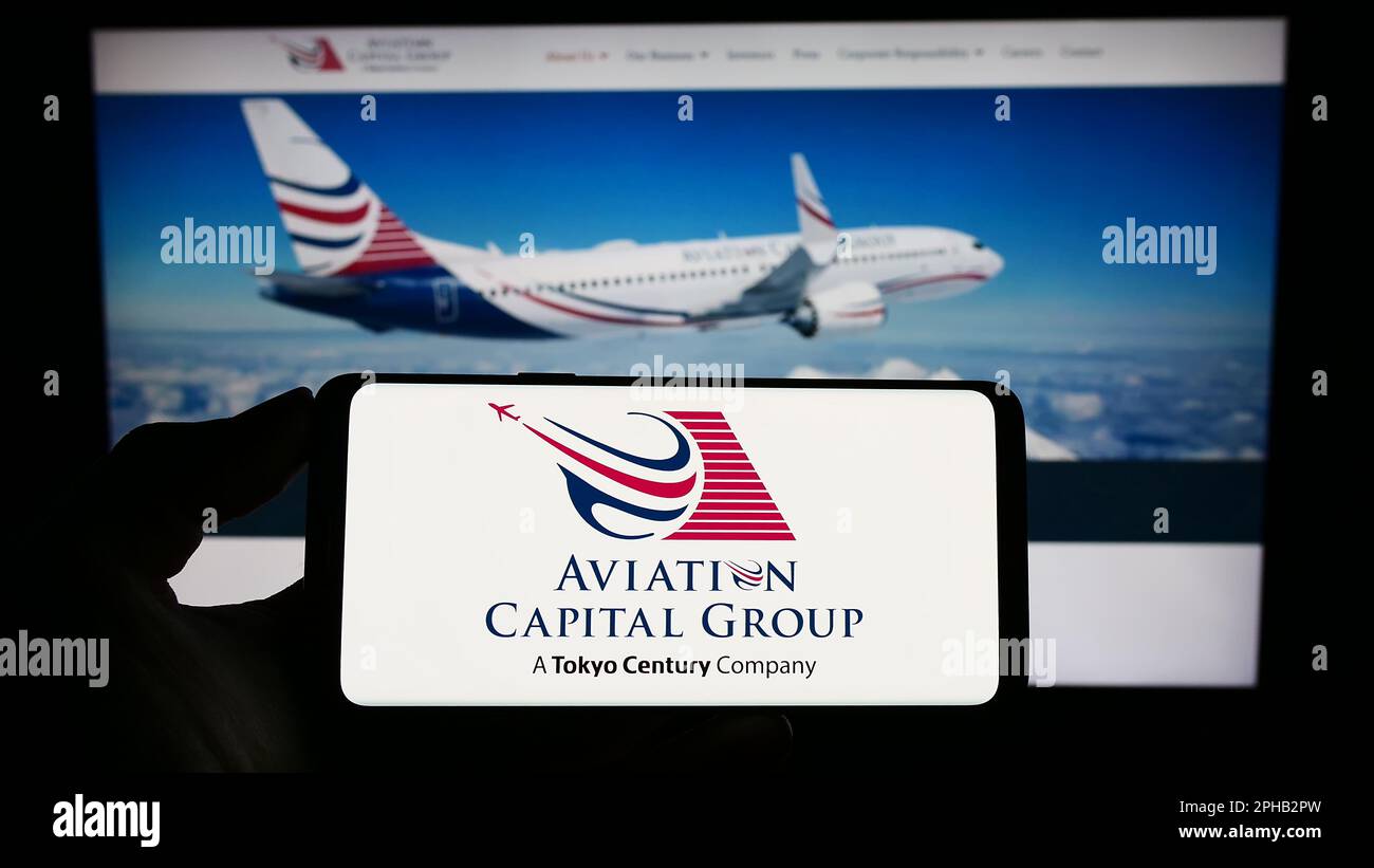 Person holding mobile phone with logo of US leasing company Aviation ...