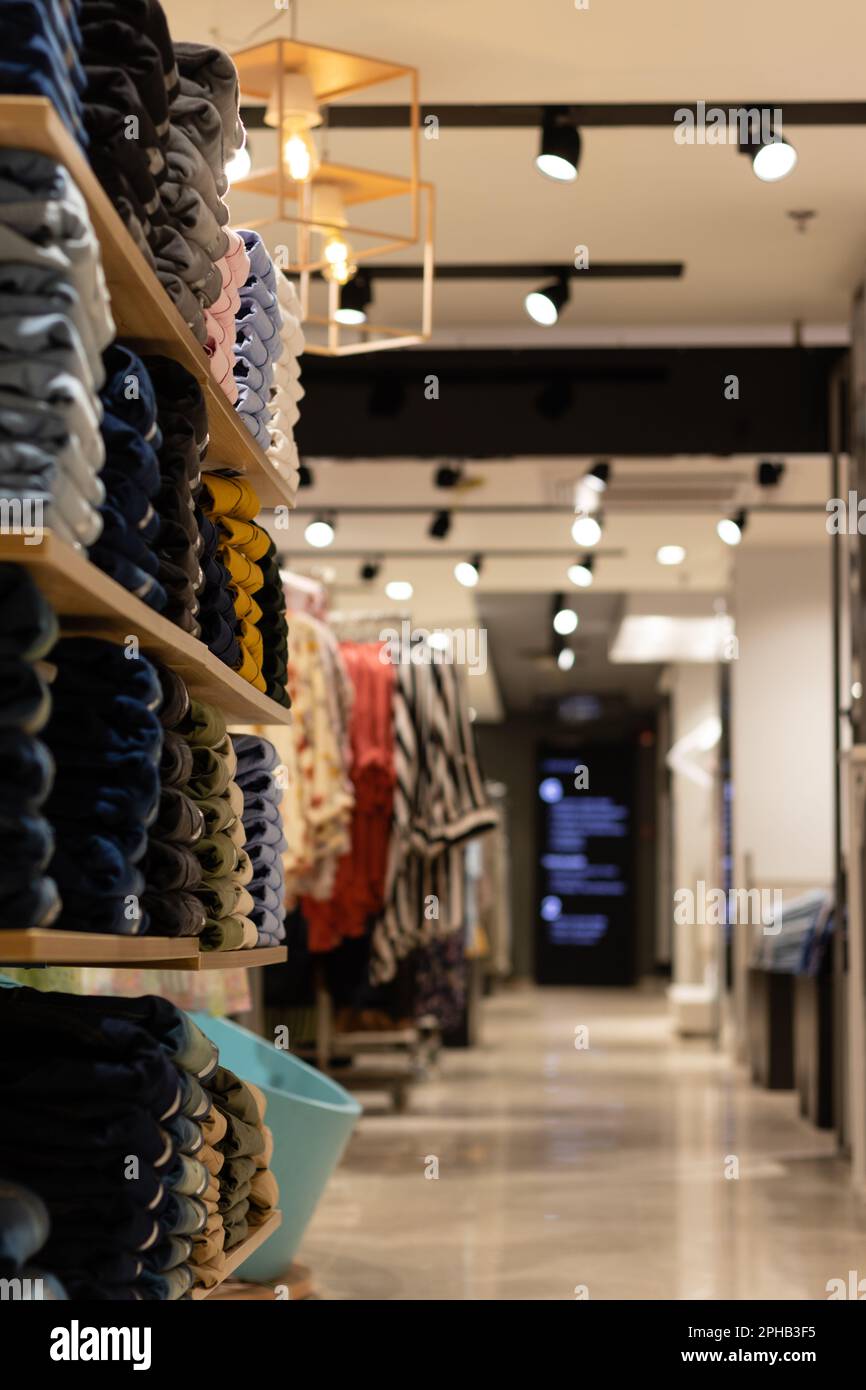 Selective focus on garments arranged in racks and hangers in a shopping ...