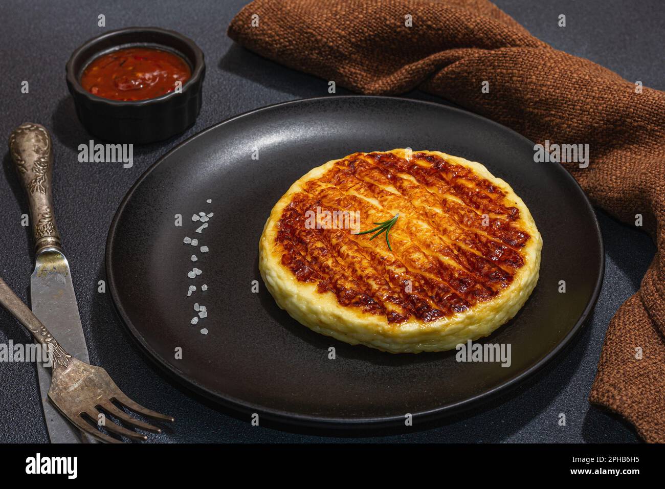 Grilled Halloumi cheese served on plate. Cutlery, traditional food for ...