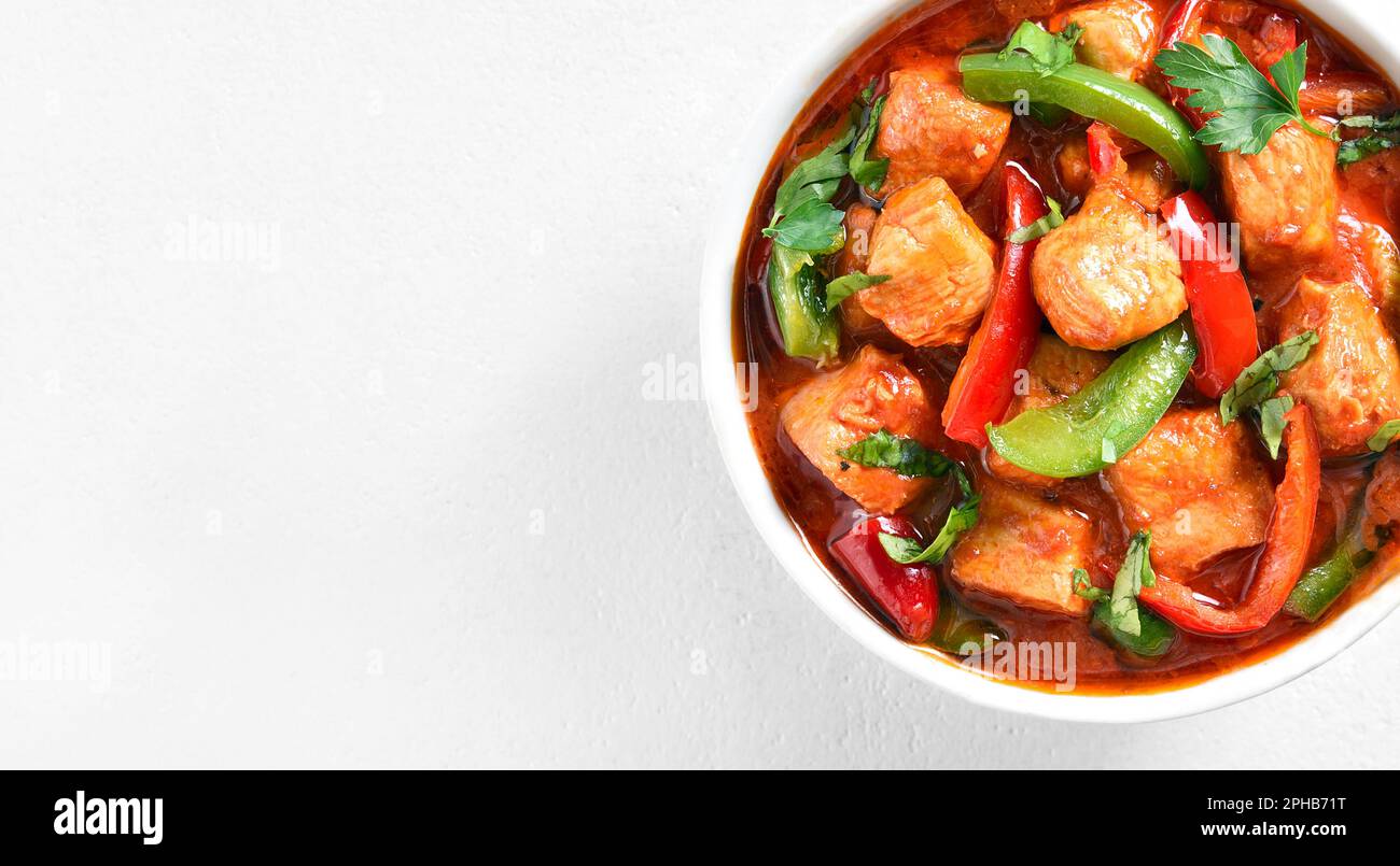 Close up view of thai style red chicken curry with vegetables in bowl ...