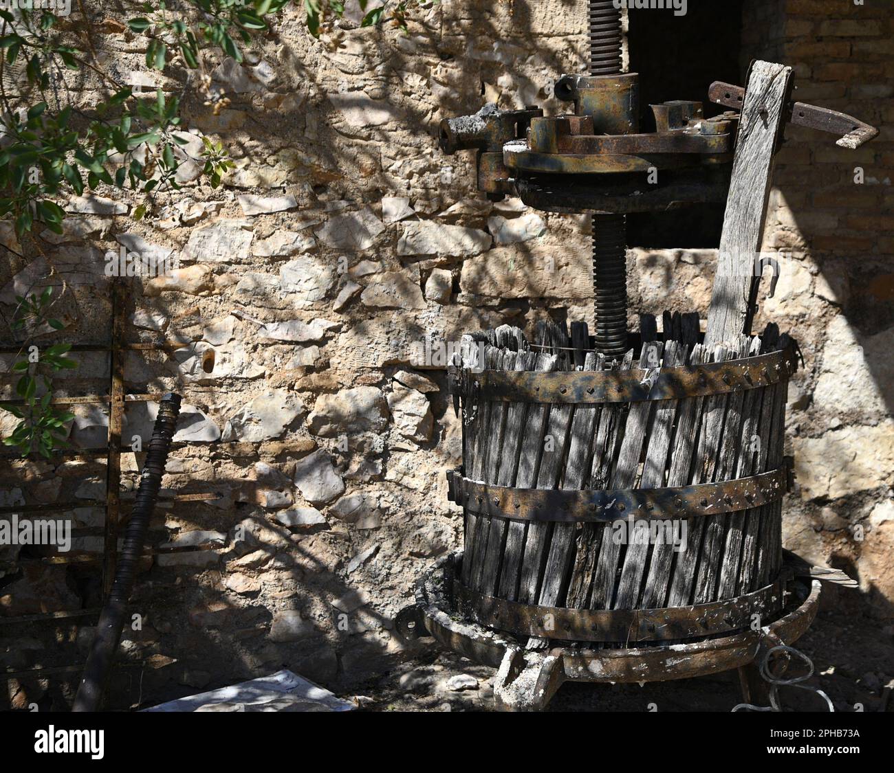 Antique manual wooden grape press against a stone wall Stock Photo - Alamy