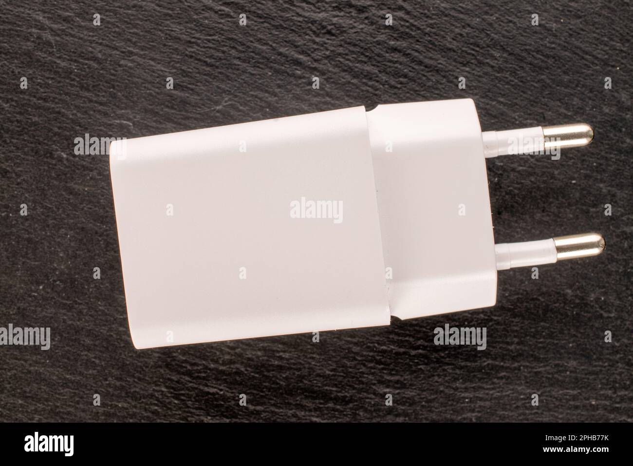 One white mains charger on slate stone, macro, top view Stock Photo - Alamy