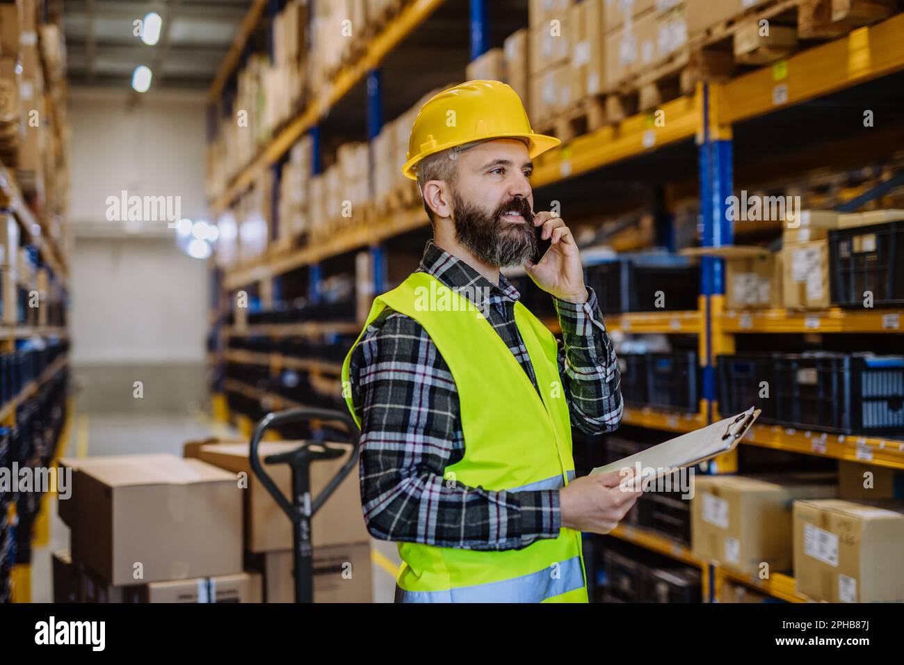 Warehouse worker calling and checking up stuff in a warehouse Stock ...