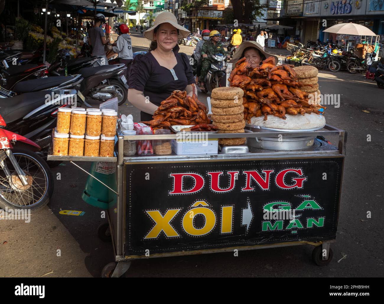 Two women stand with their street food stall selling sticky rice with ...
