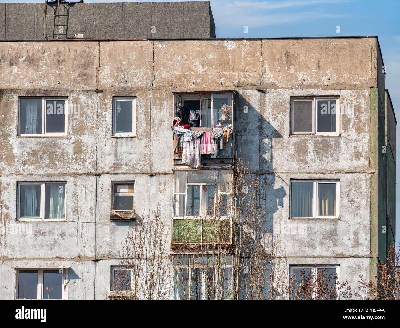 Worn out apartment building from the communist era against blue sky in ...