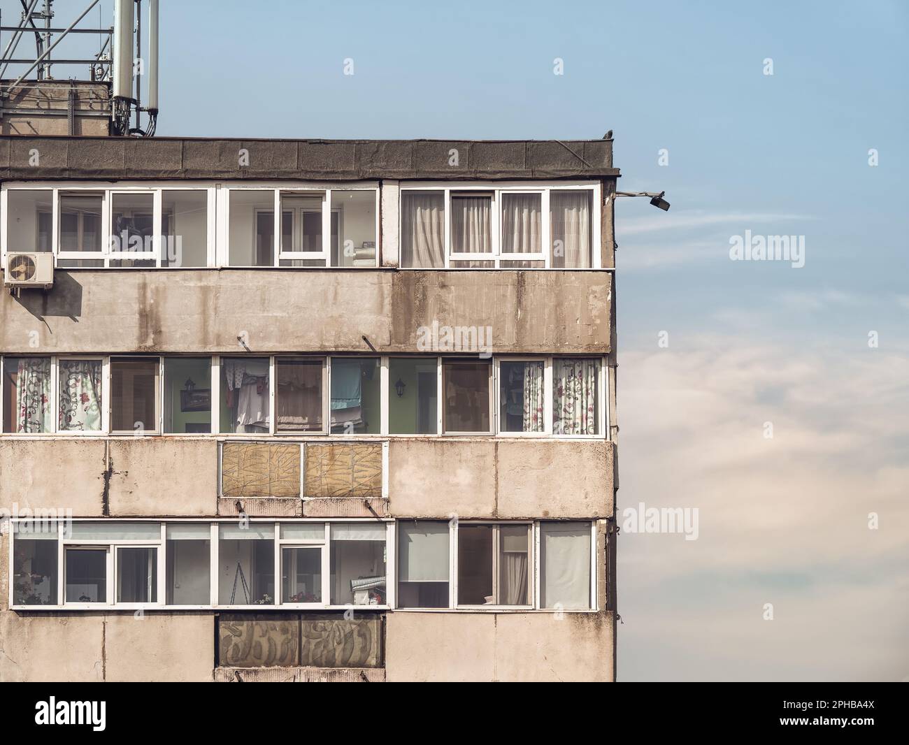 Worn out apartment building from the communist era against blue sky in ...