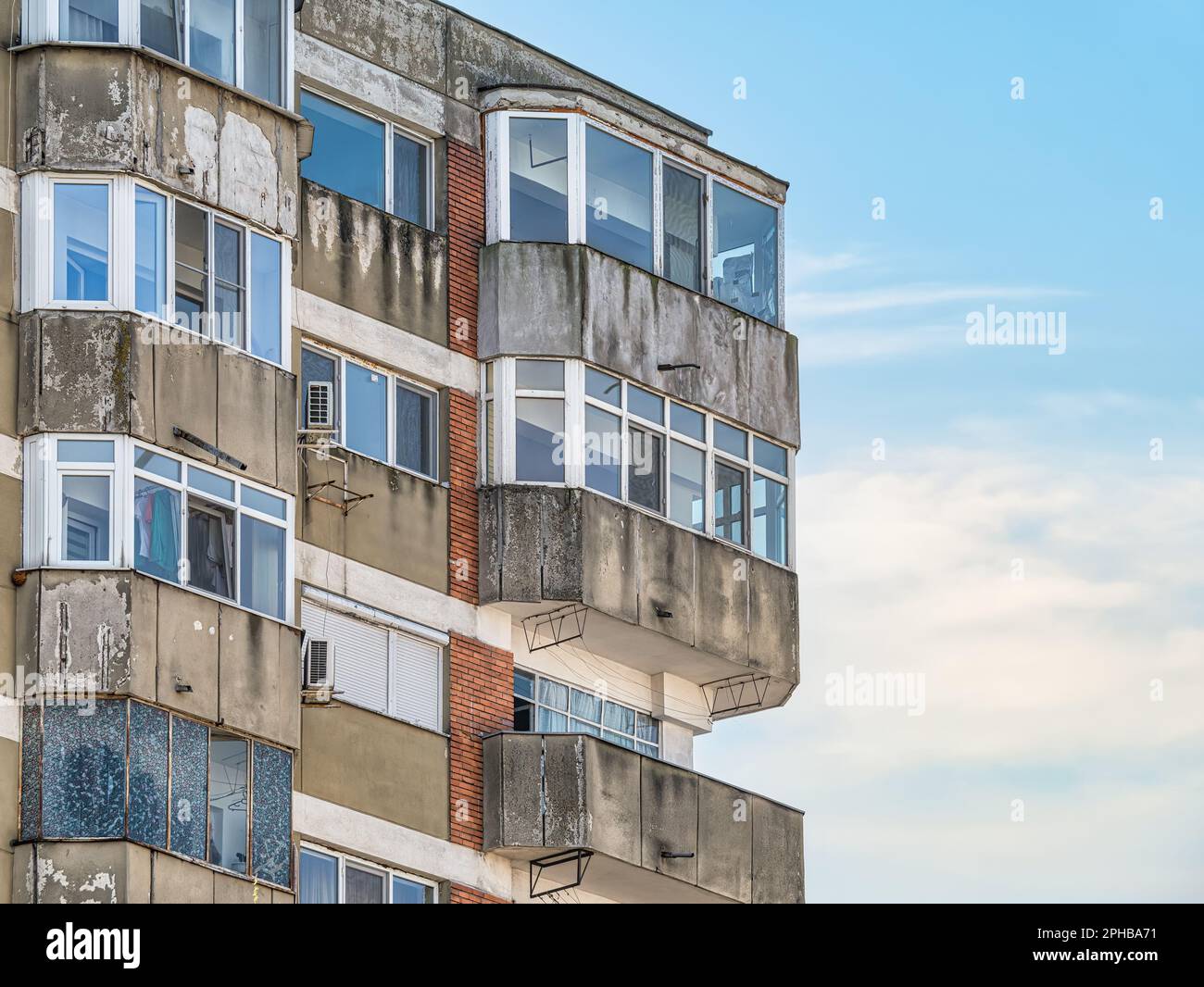 Worn out apartment building from the communist era against blue sky in ...