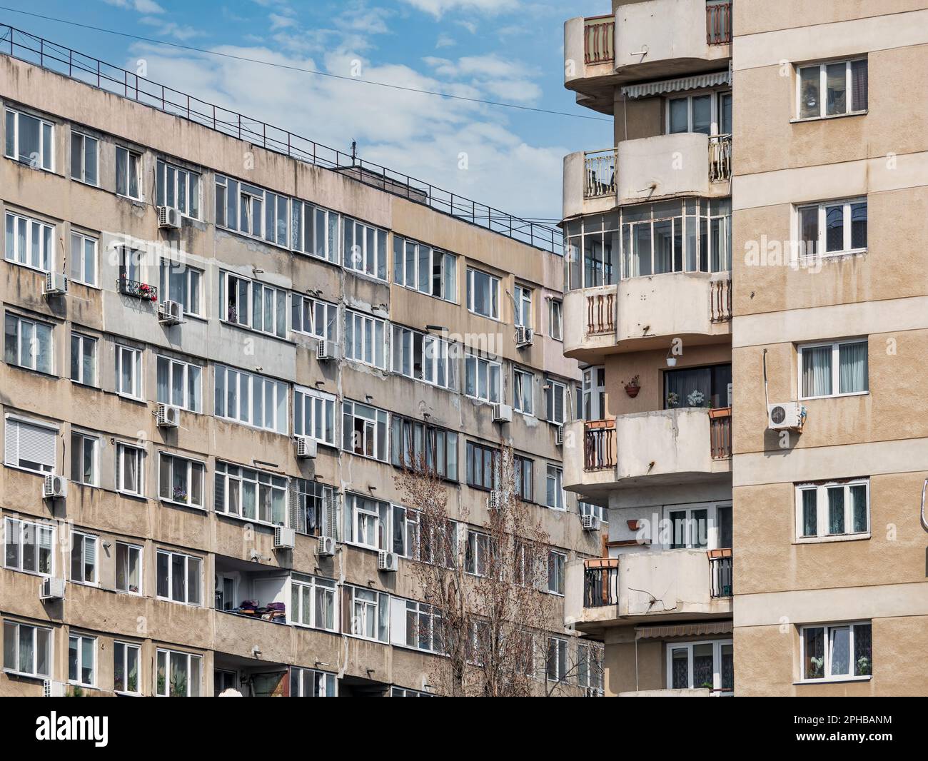 Worn out apartment building from the communist era against blue sky in ...
