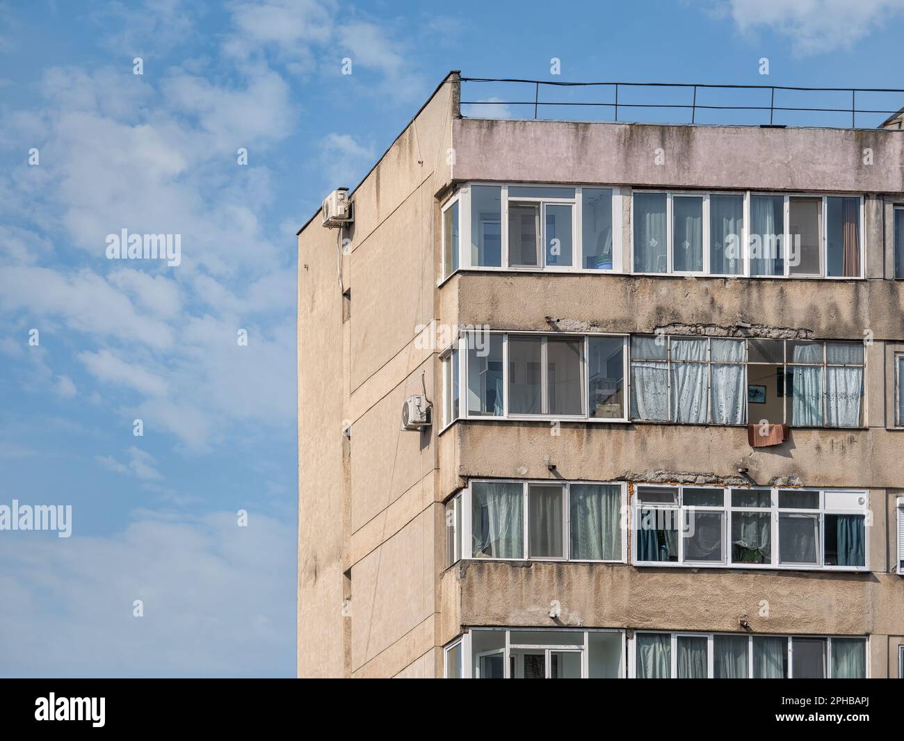 Worn out apartment building from the communist era against blue sky in ...