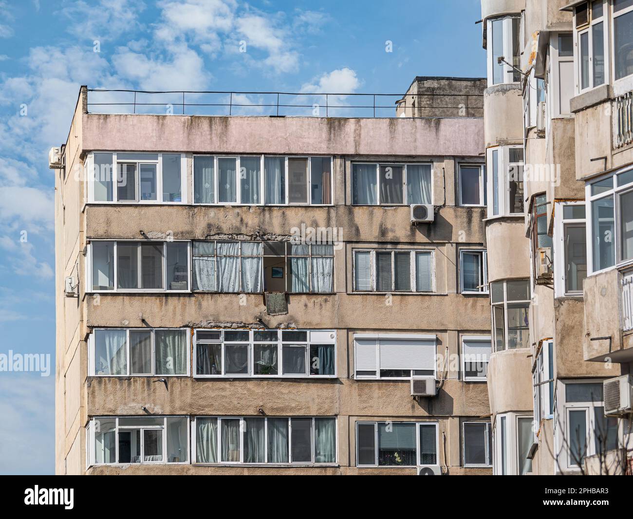 Worn out apartment building from the communist era against blue sky in ...