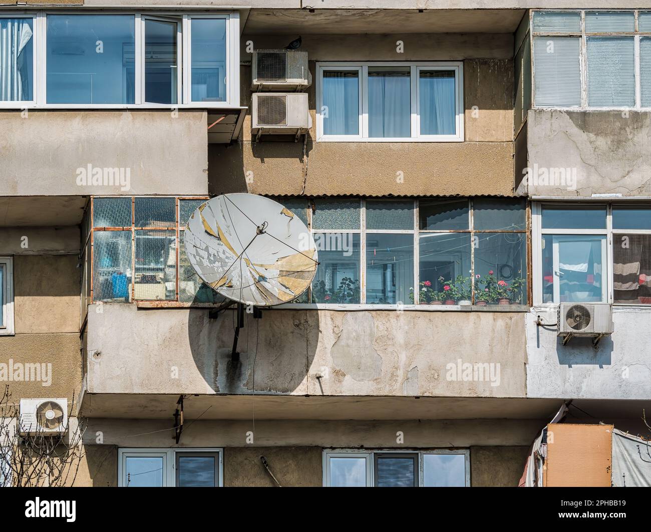 Worn out apartment building from the communist era against blue sky in ...