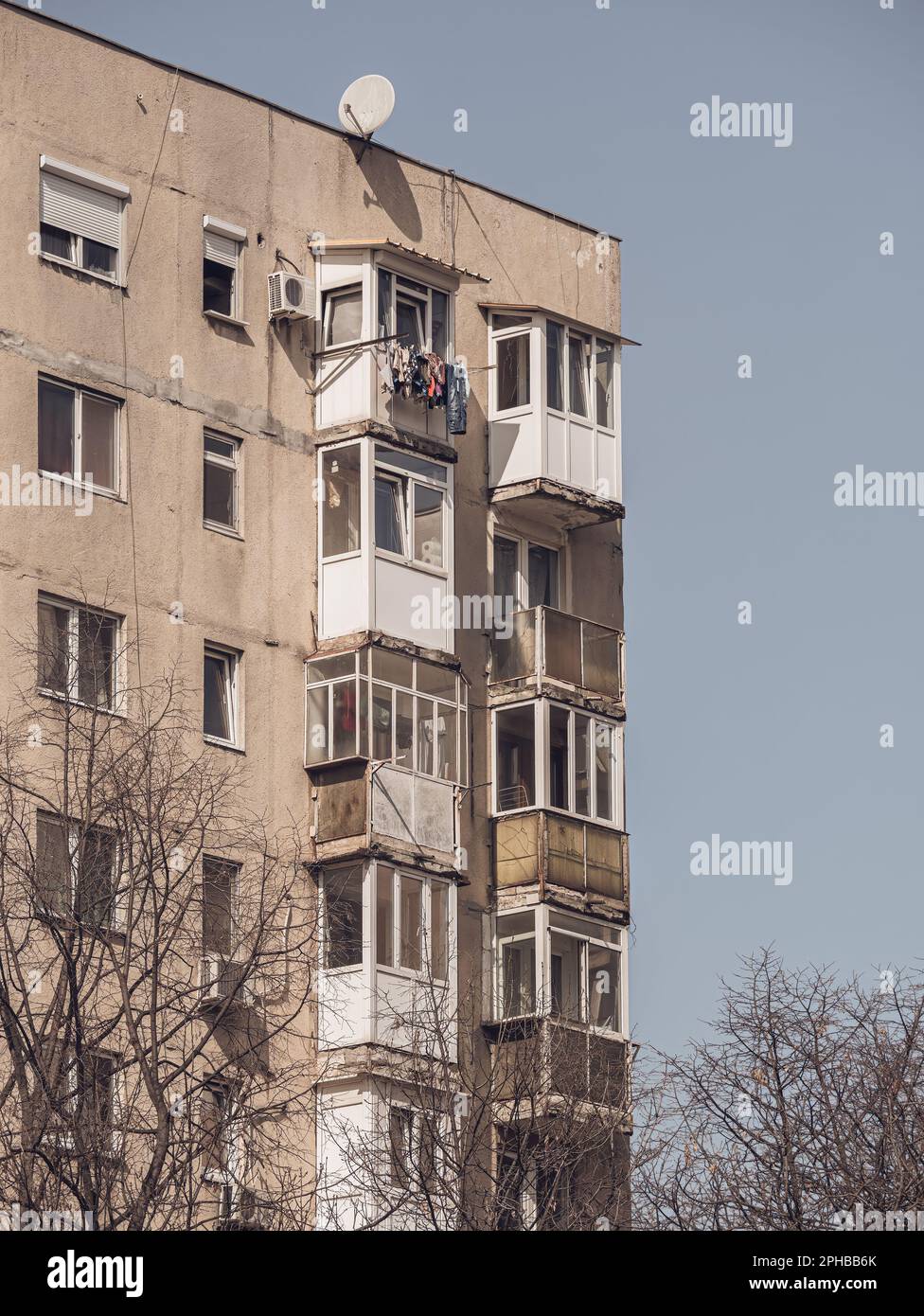 Worn out apartment building from the communist era against blue sky in ...