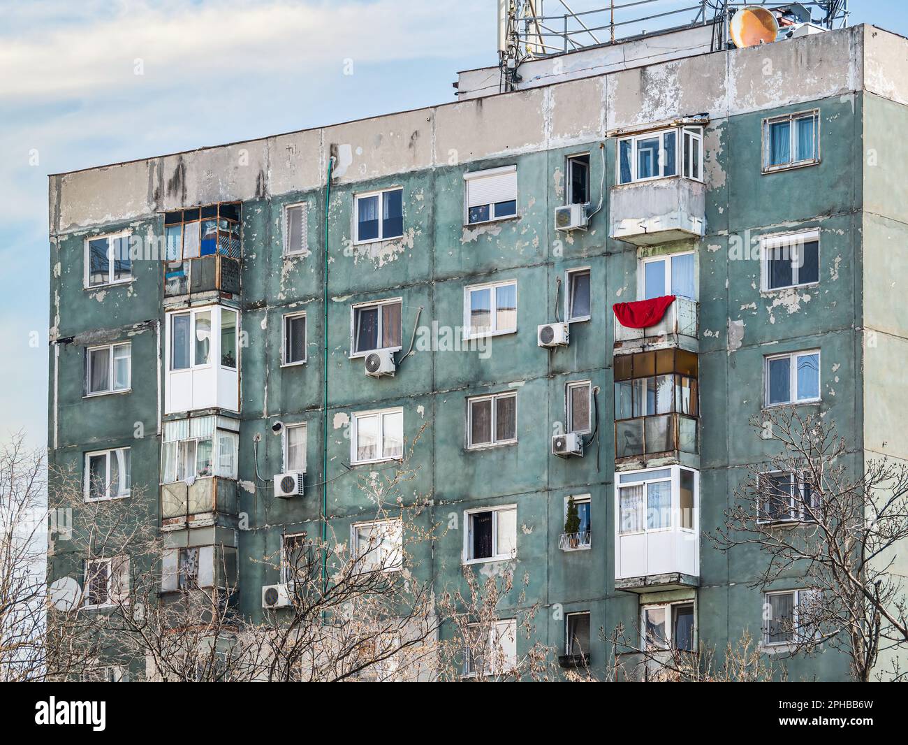 Worn out apartment building from the communist era against blue sky in ...
