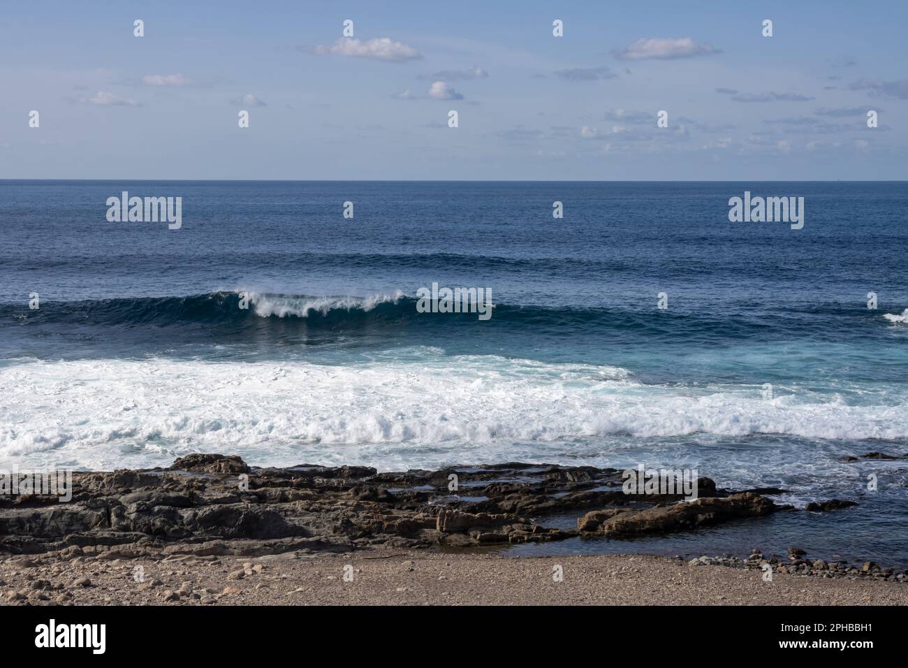 Beach of the Atlantic ocean with a rocky coast. Calm water in the ...