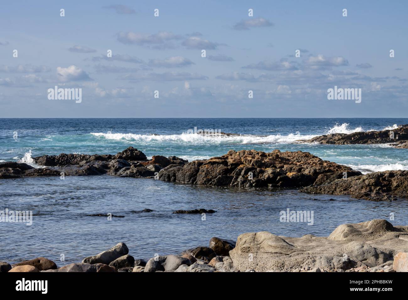 Beach of the Atlantic ocean with a rocky coast. Calm water in the ...