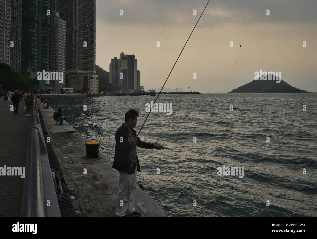 A man fishing by the Belcher Bay Promenade in Kennedy Town. 14MAR23 ...