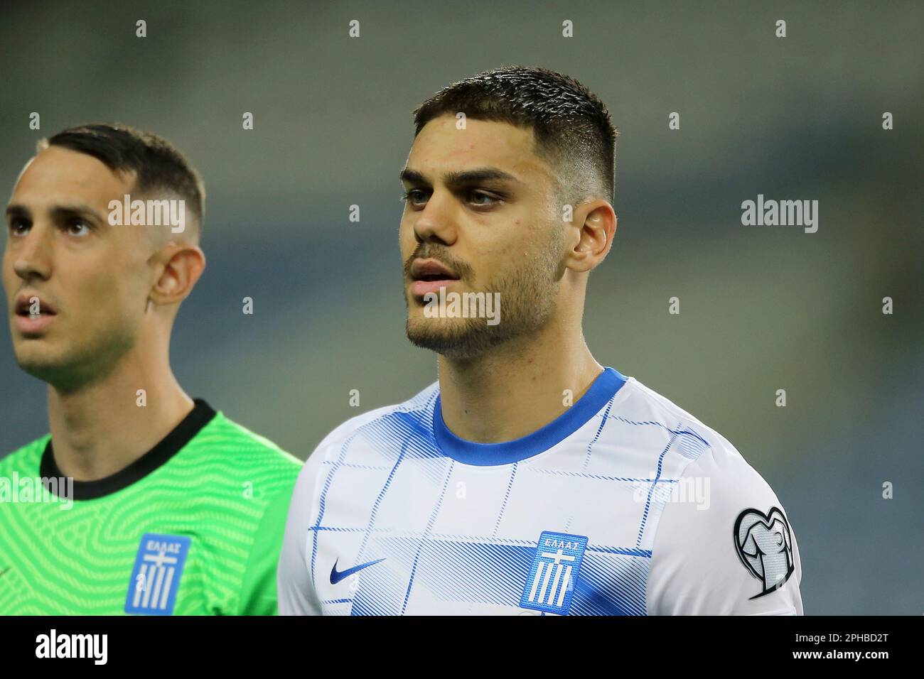Greece's Konstantinos Mavropanos stands on the pitch, next to ...