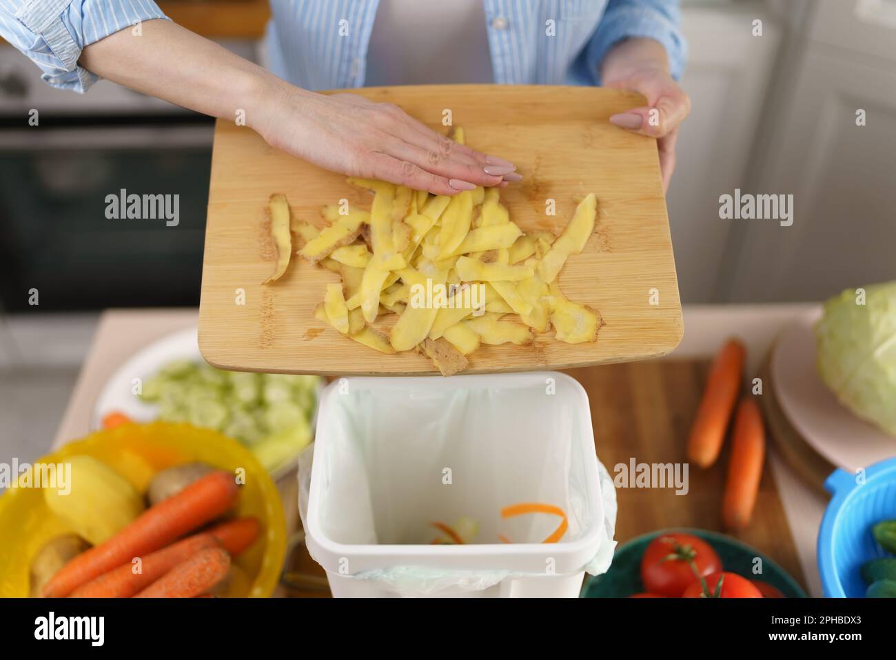 Woman throwing away potato peels for recycling. Female composting ...