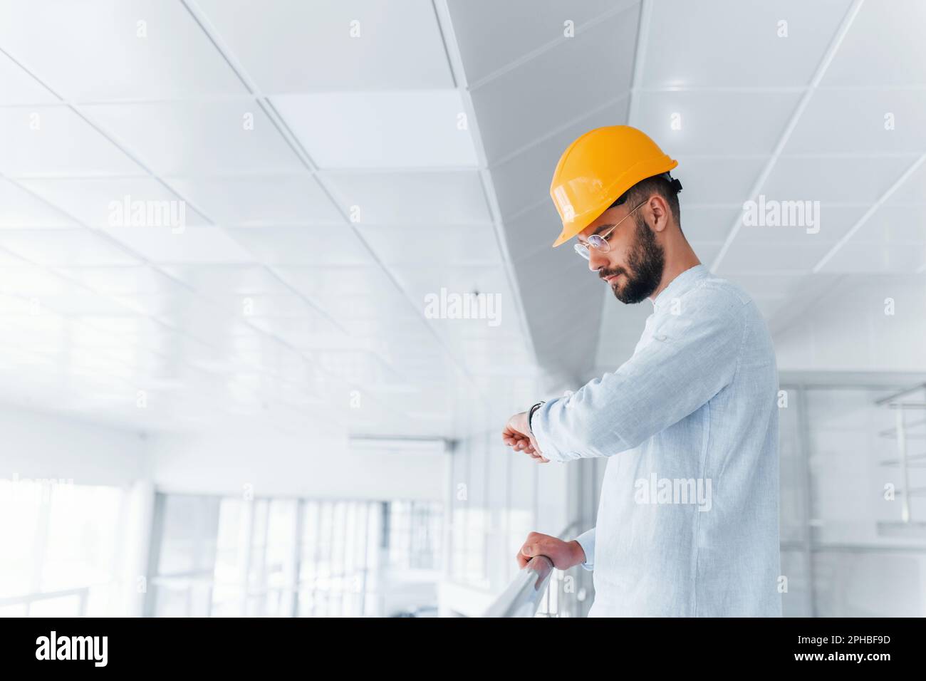 Front view of engineer in white clothes and orange protective hard hat ...