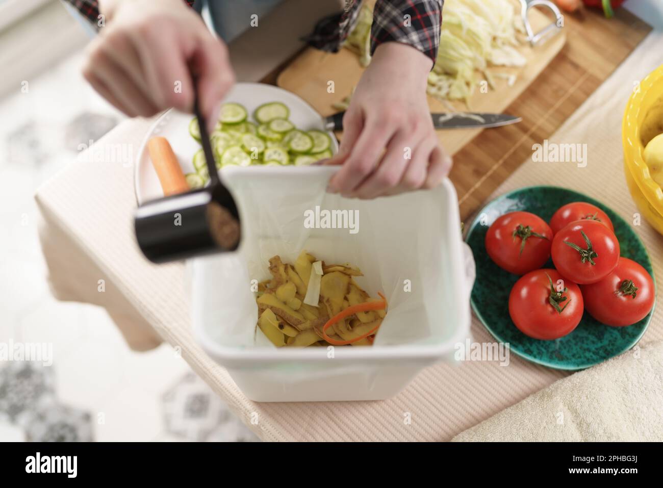 Woman composting food waste at home. Female making a compost with ...