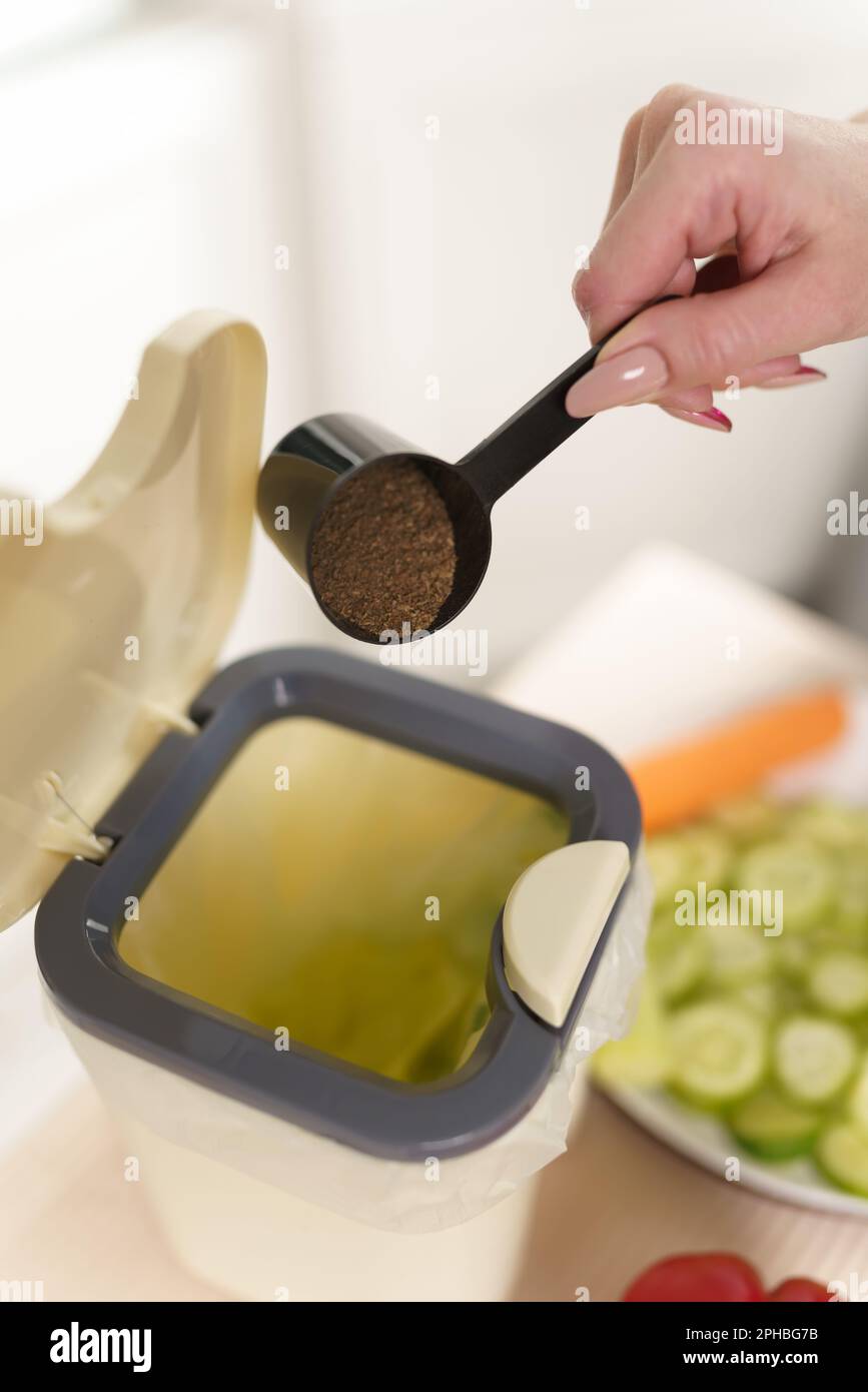 Person making a compost at home. Female composting food leftovers with ...