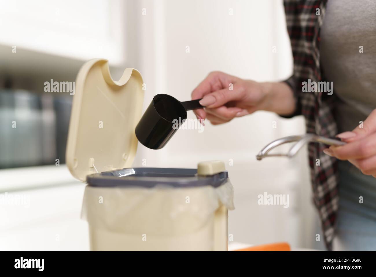 Woman fermenting organic food waste in a composter. Female composting ...